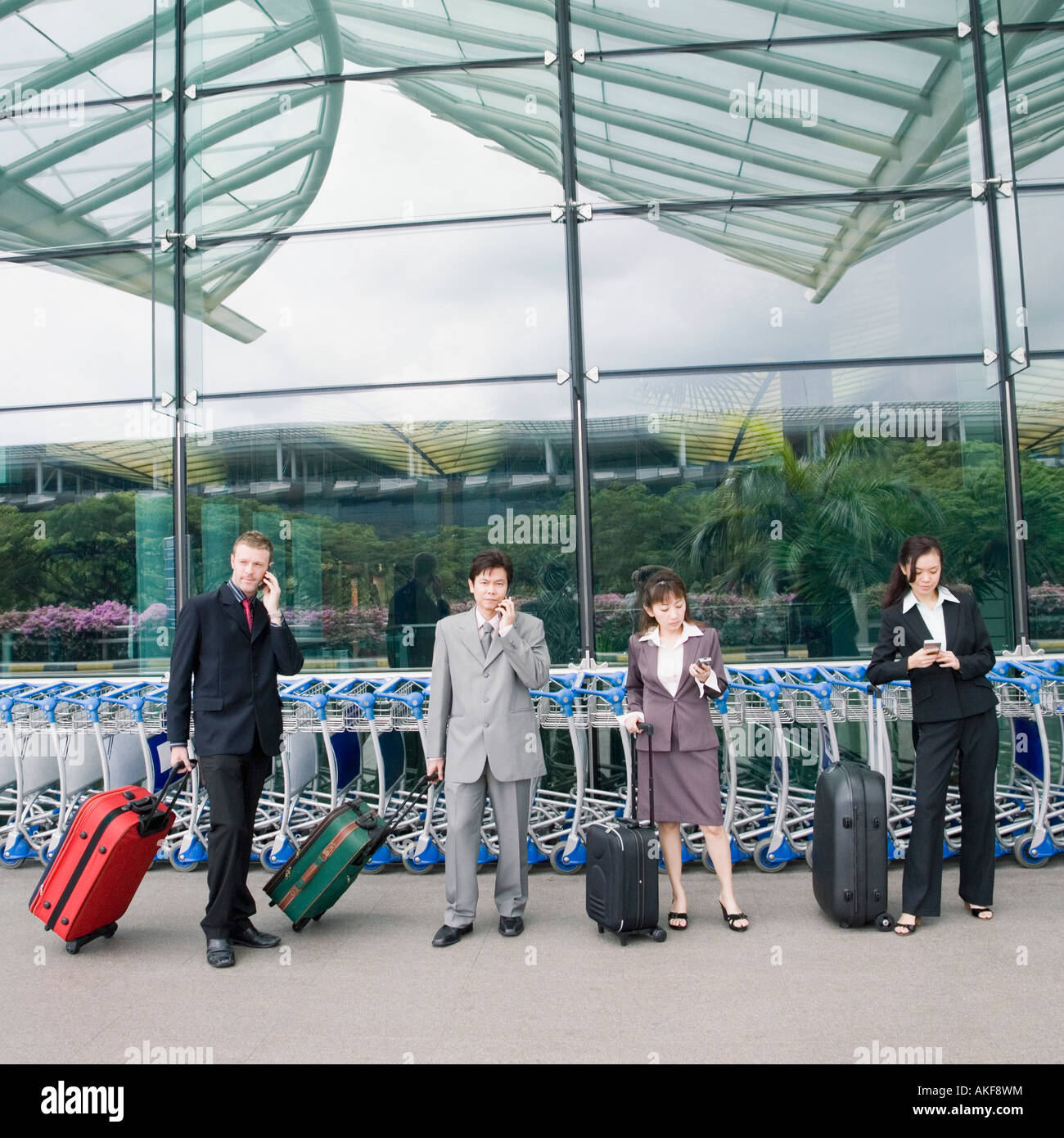Two businesswomen with two businessmen waiting at an airport Stock ...