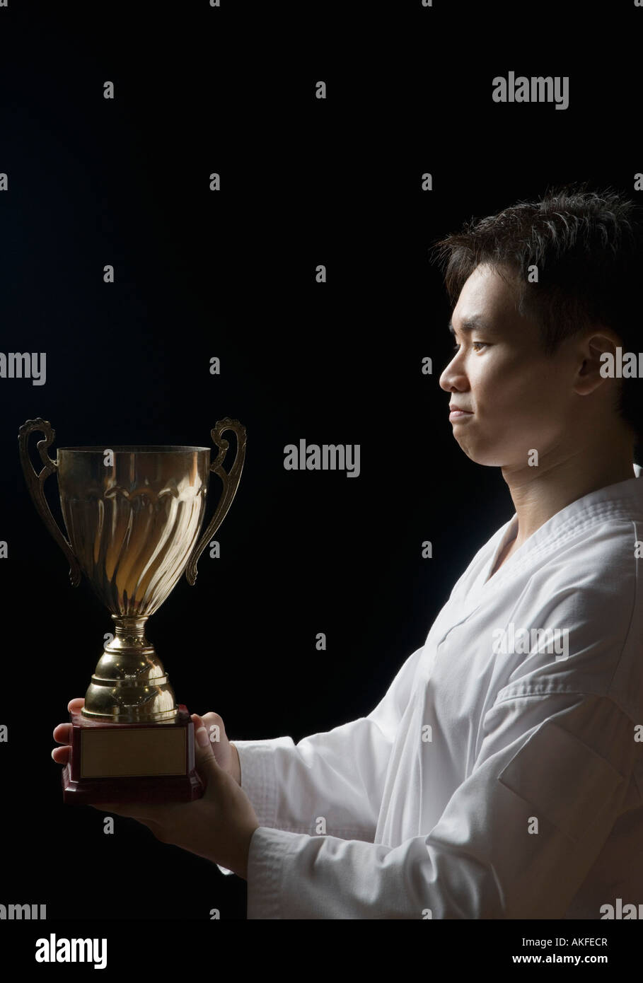 Side profile of a young man holding a trophy Stock Photo - Alamy