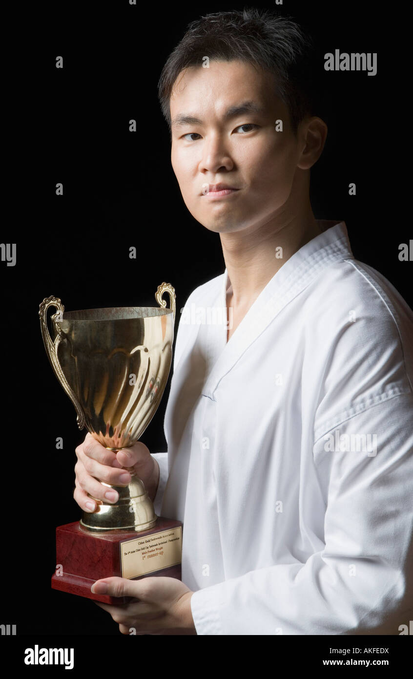 Portrait of a young man holding a trophy Stock Photo - Alamy