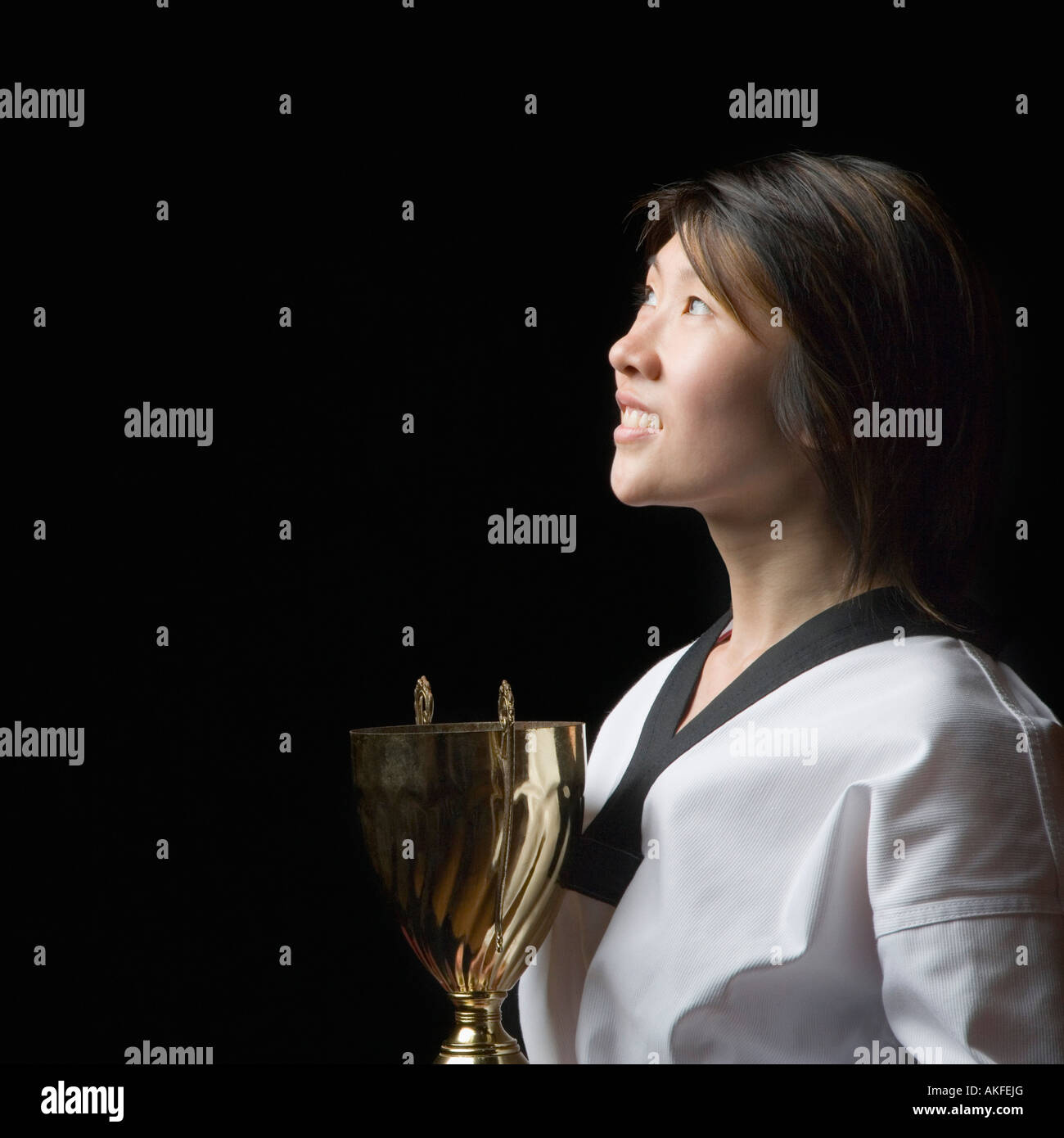 Side profile of a young woman holding a trophy Stock Photo - Alamy