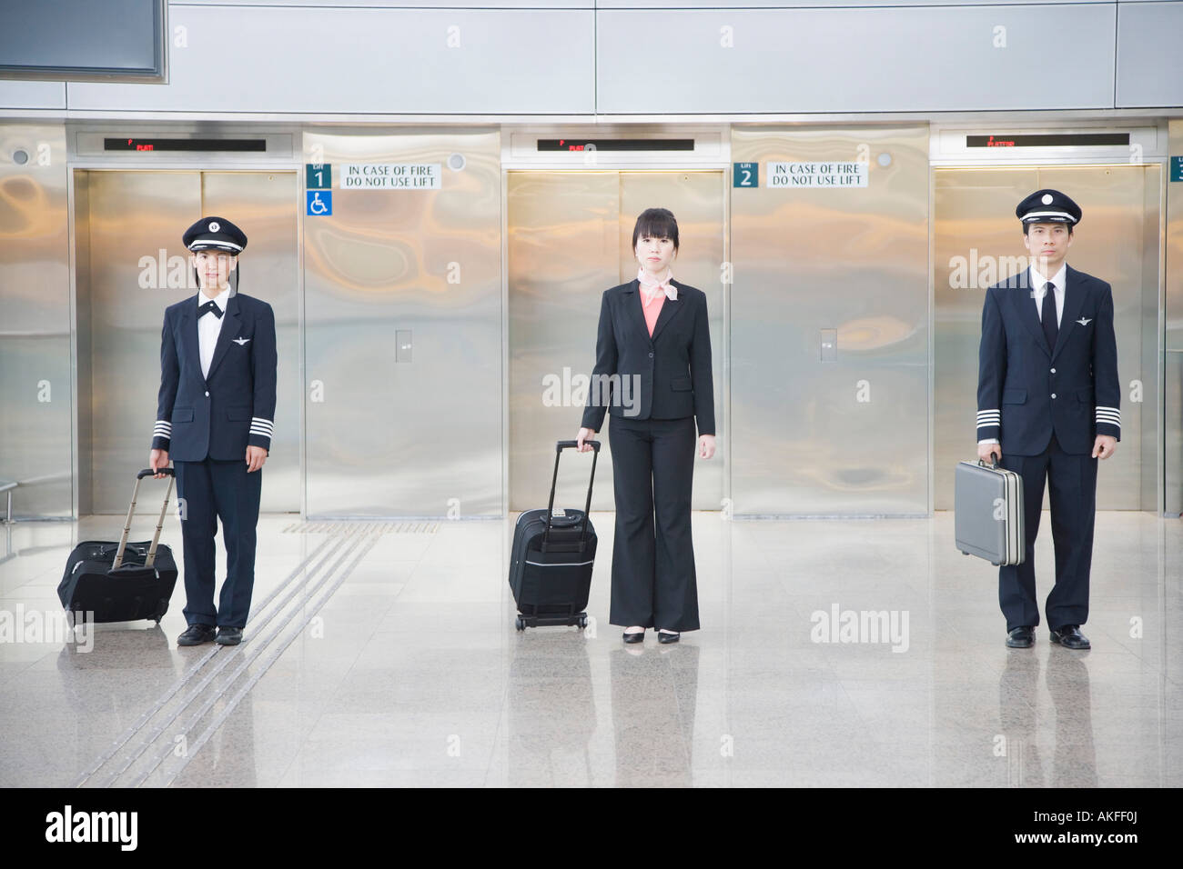 Male and a female pilot standing with a female cabin crew in front of ...