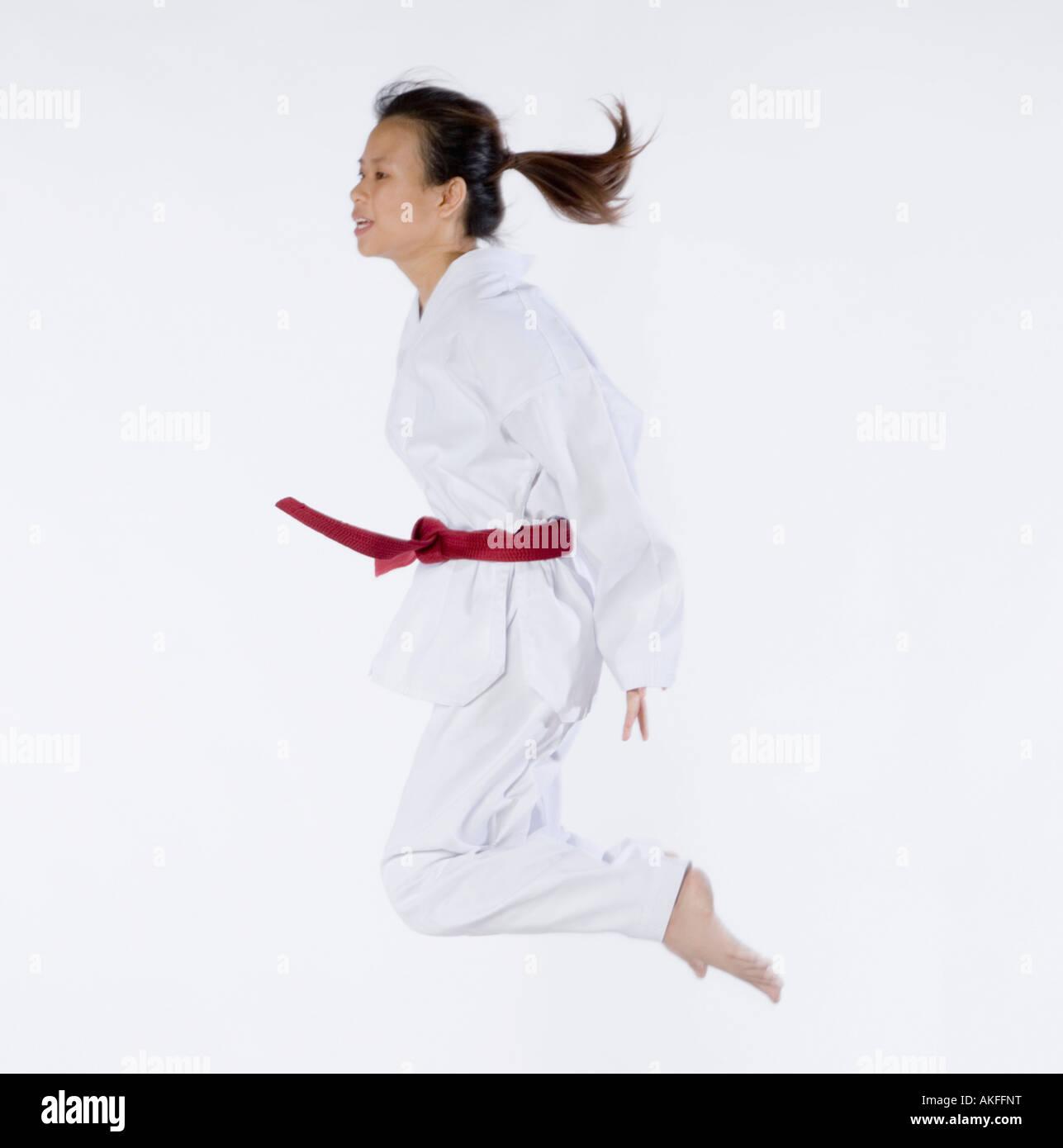 Side profile of a young woman jumping and practicing martial arts Stock ...