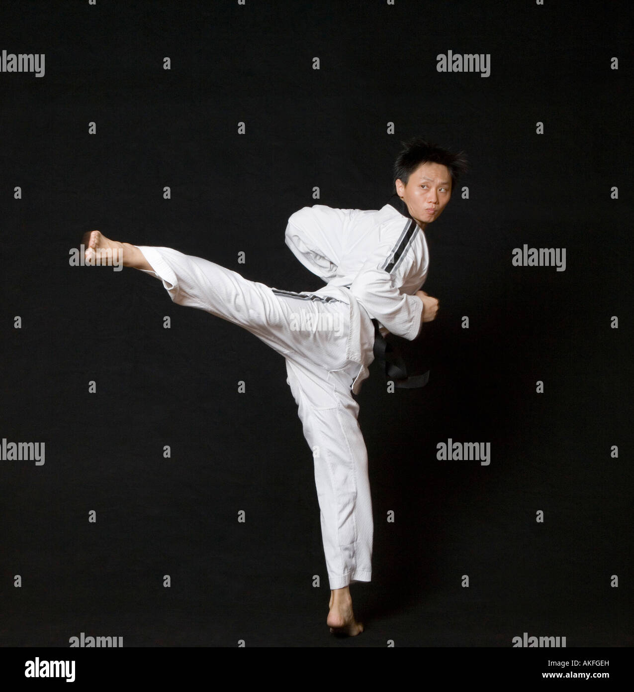Mid adult man performing the side kick Stock Photo - Alamy
