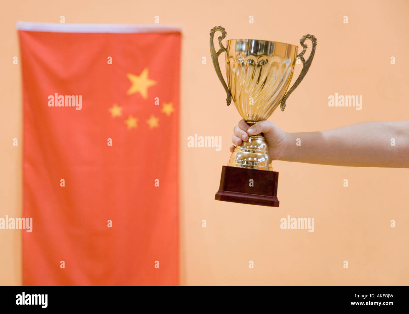 Close-up of a person's hand holding a golden trophy cup Stock Photo - Alamy