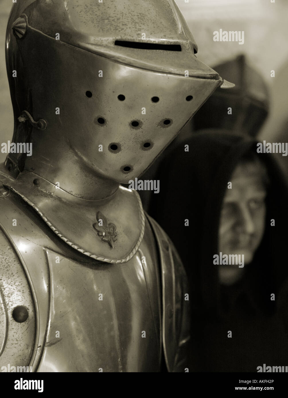 Medieval suit of armour with mannequin model of a monk in background ...