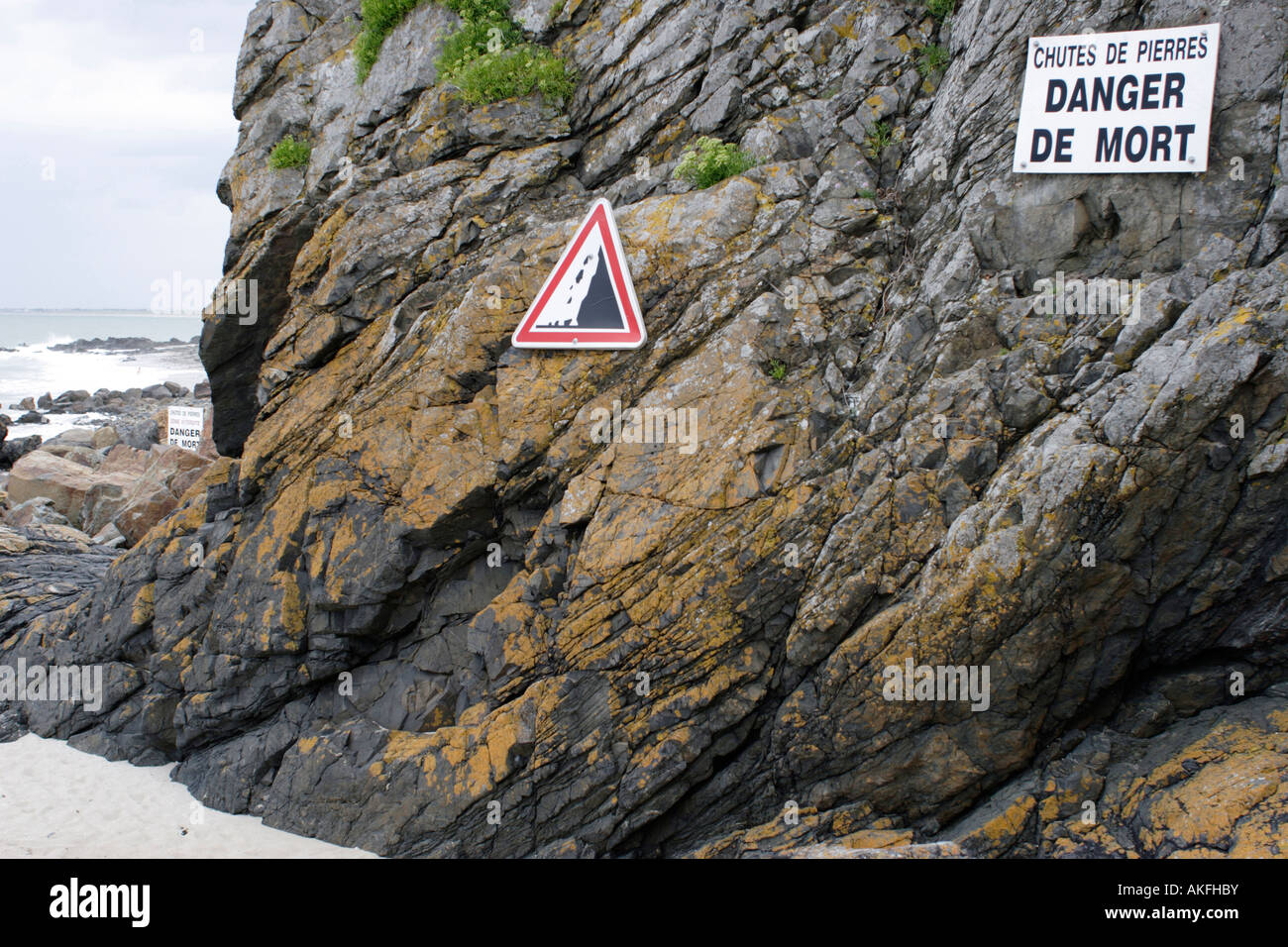 Danger of Death falling rock warning signs at cliff base Normandy ...