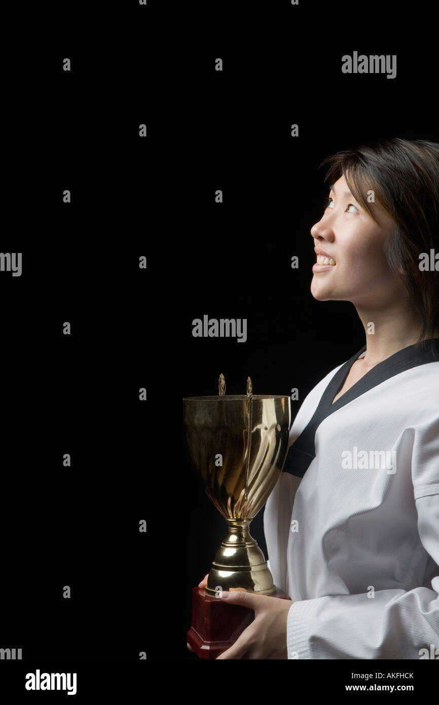 Side profile of a young woman holding a trophy Stock Photo - Alamy
