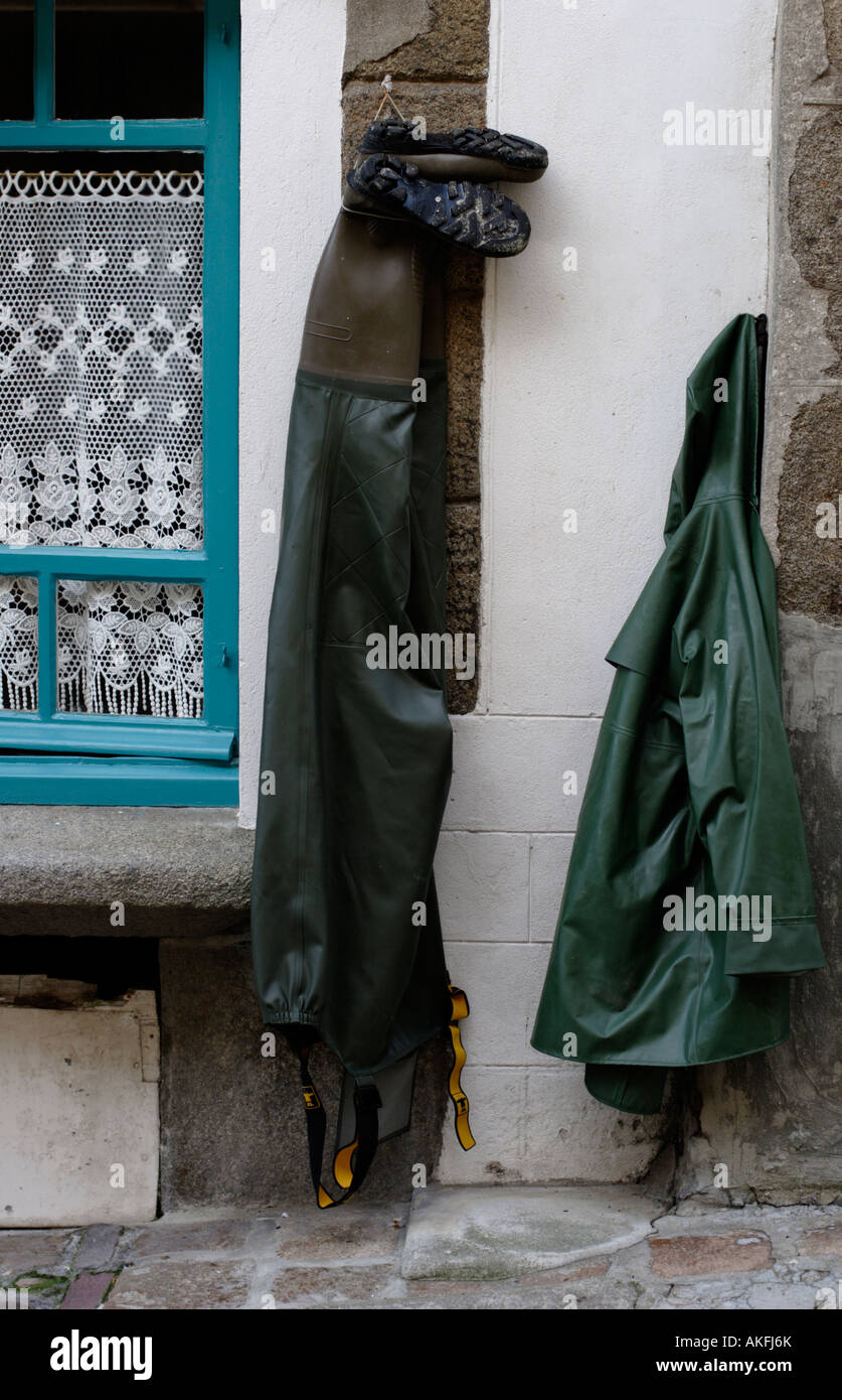 Fishermans waders and coat hanging out to dry in front of cottage in ...