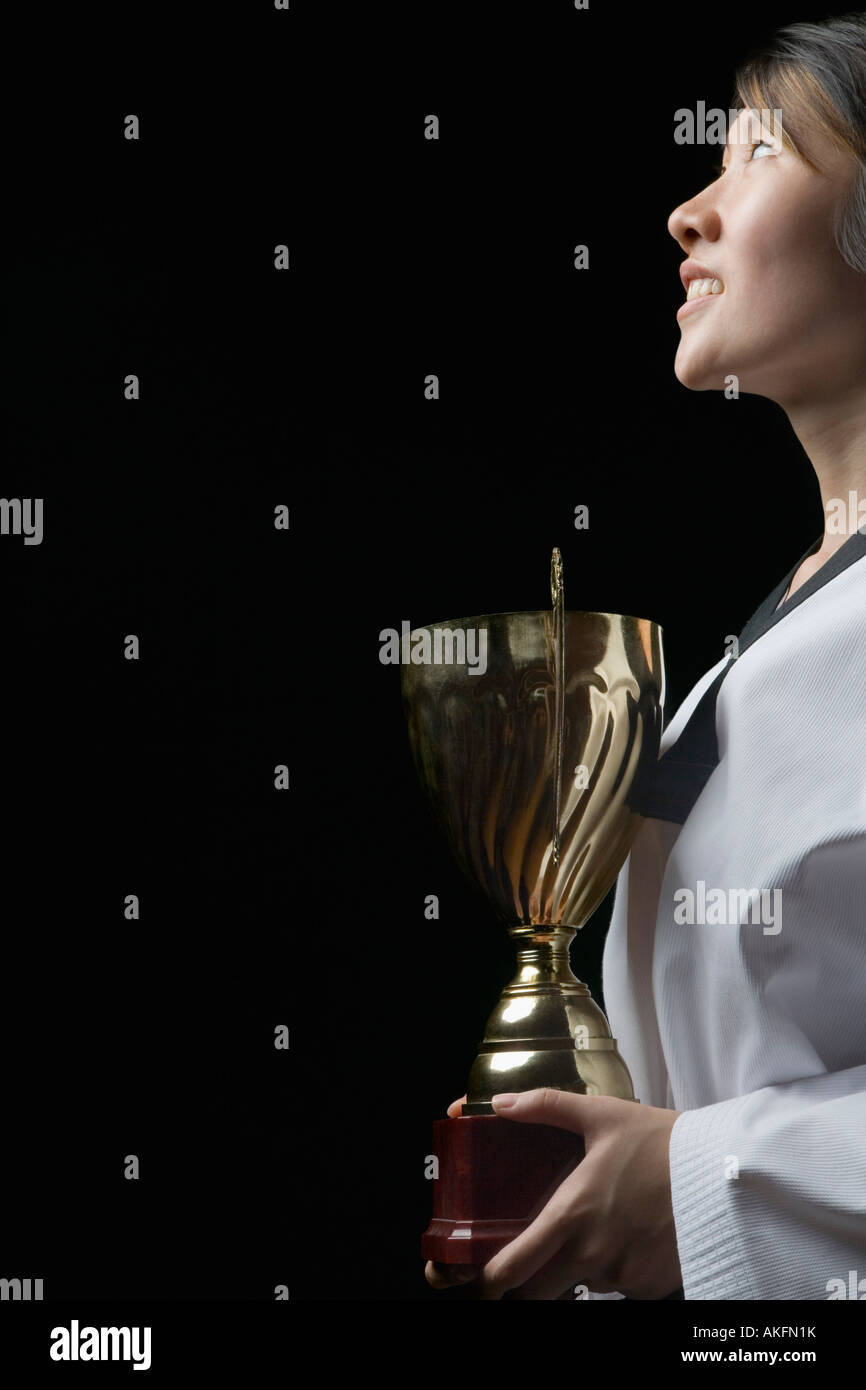 Side profile of a young woman holding a trophy Stock Photo - Alamy