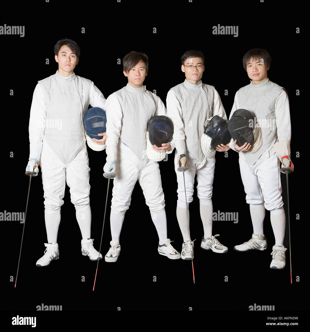 Portrait of four male fencers holding fencing foils and fencing masks ...