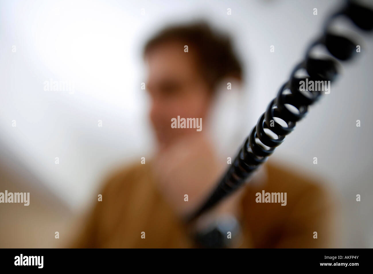 Man making telephone call with focus on the telephone cable Stock Photo ...