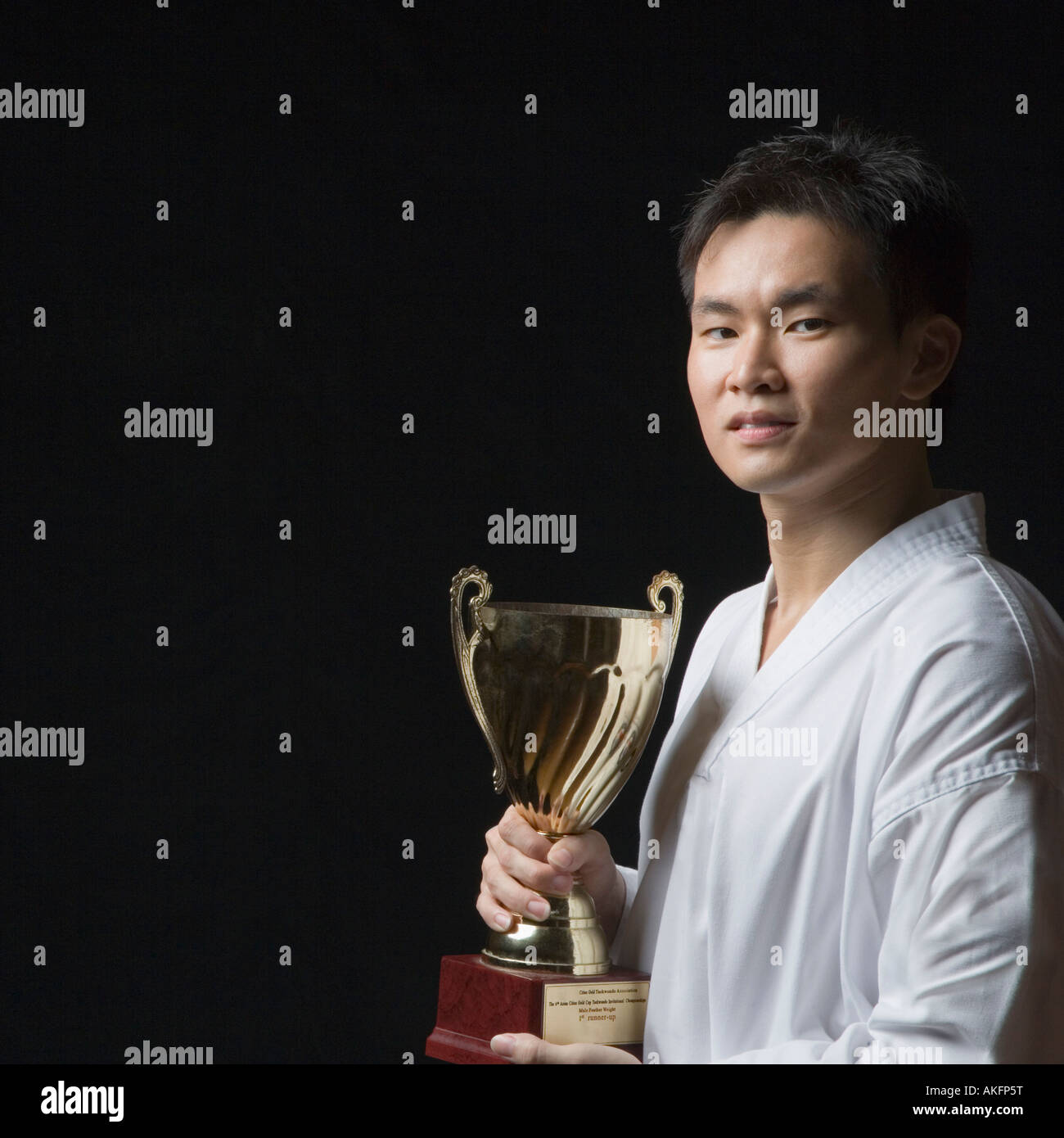 Portrait of a young man holding a trophy Stock Photo - Alamy