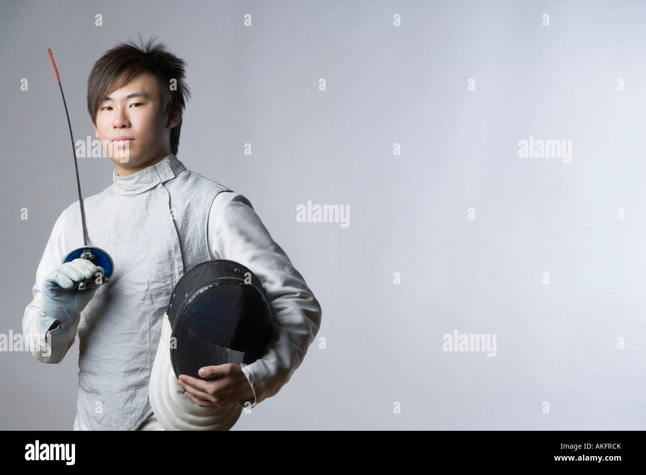 Portrait of a male fencer holding a sword and a fencing mask Stock ...