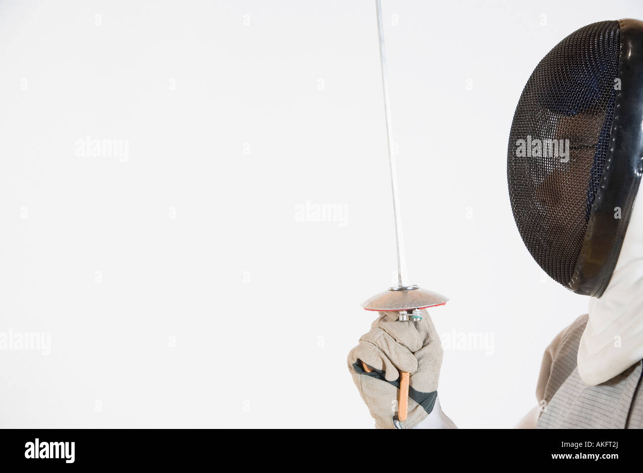 Close-up of a person wearing a fencing mask and holding a fencing foil ...