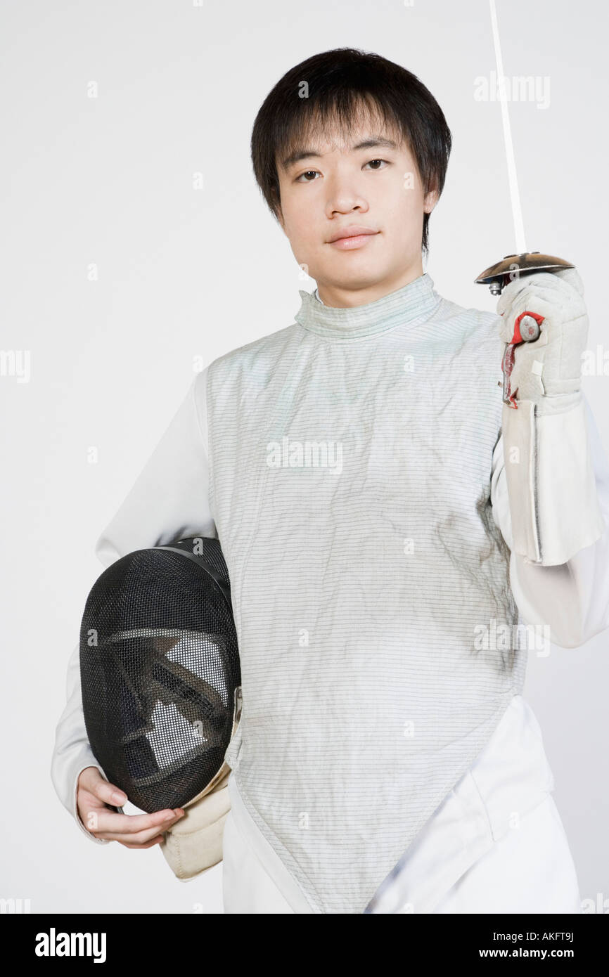 Portrait of a male fencer holding a fencing foil and a fencing mask ...