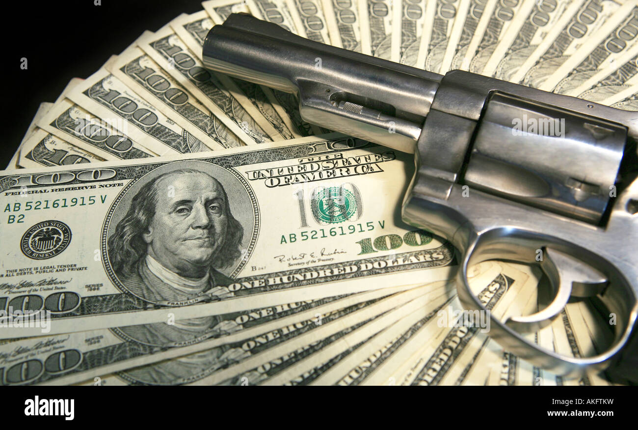 Hand gun on top on one hundred dollar bills isolated on white ...