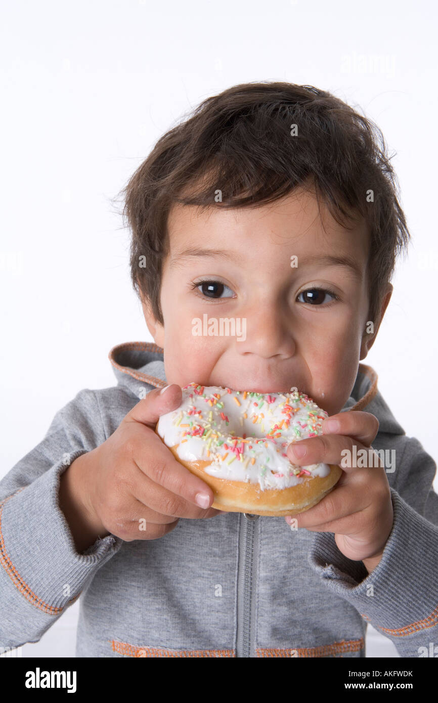 Little boy eating a donut Stock Photo - Alamy