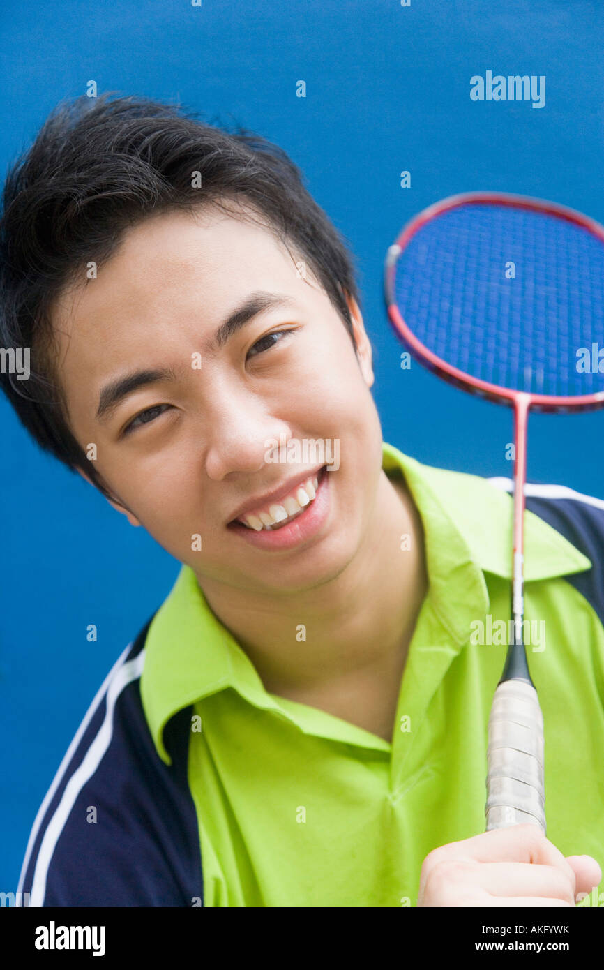 Portrait of a young man holding a badminton racket and smiling Stock ...