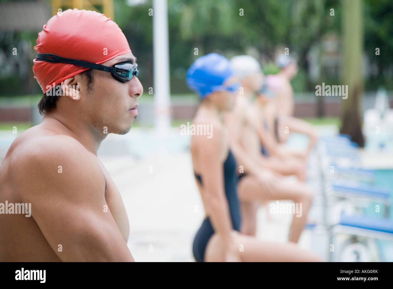 Side profile of a young man wearing swimming goggles and standing at a ...