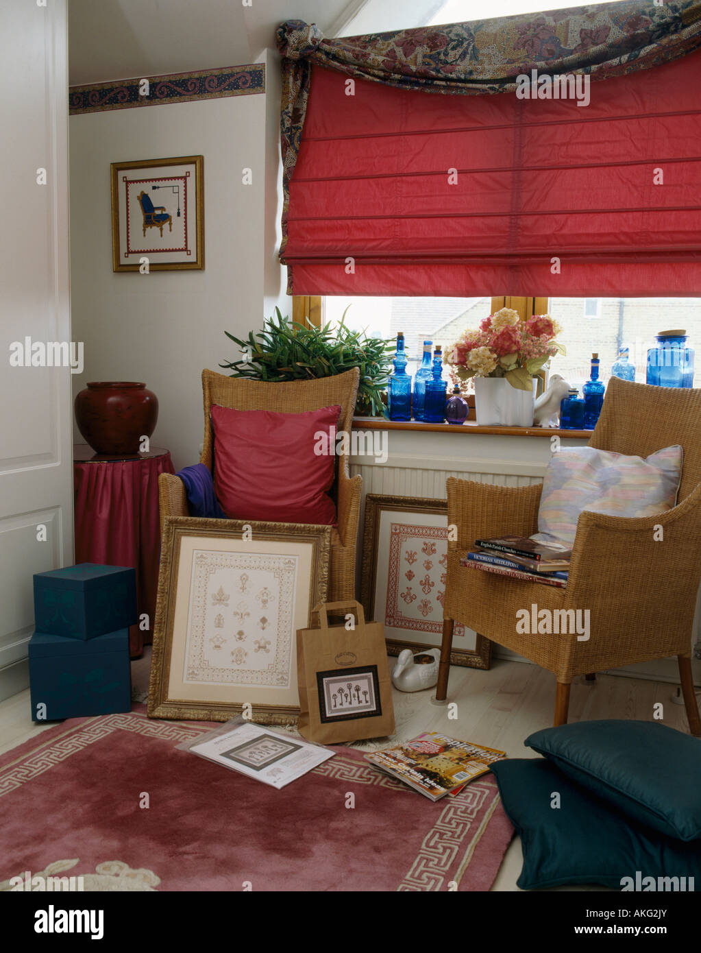 Cross stitch pictures in country workroom with red blind and wicker ...