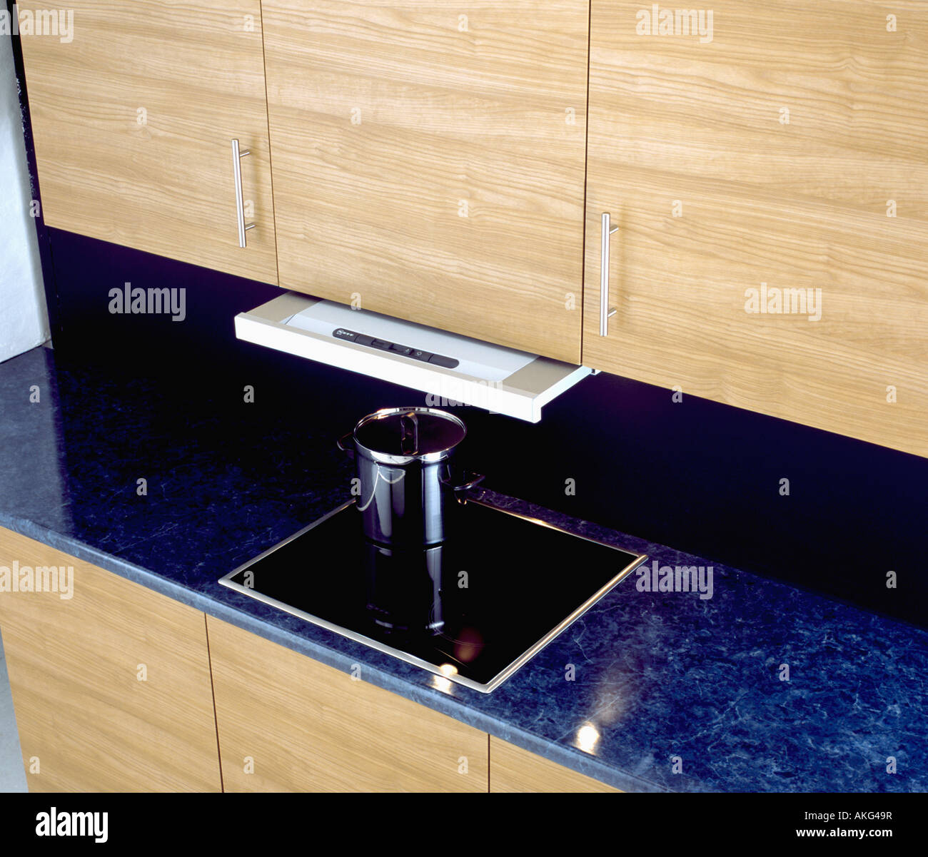 Close up of pan on hob in worktop below extractor fan Stock Photo - Alamy