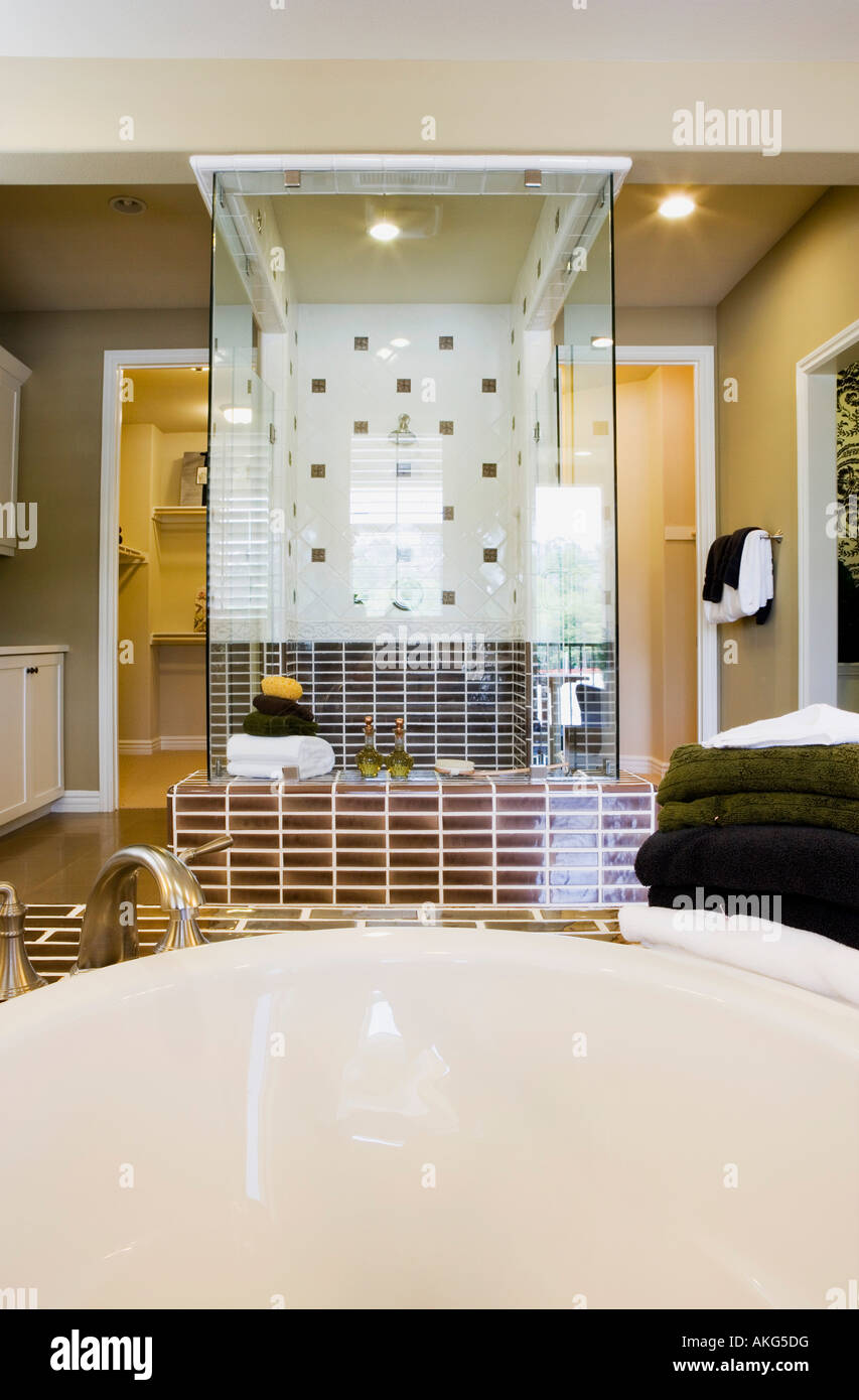 Image of bathtub and towels with shower in background Stock Photo - Alamy