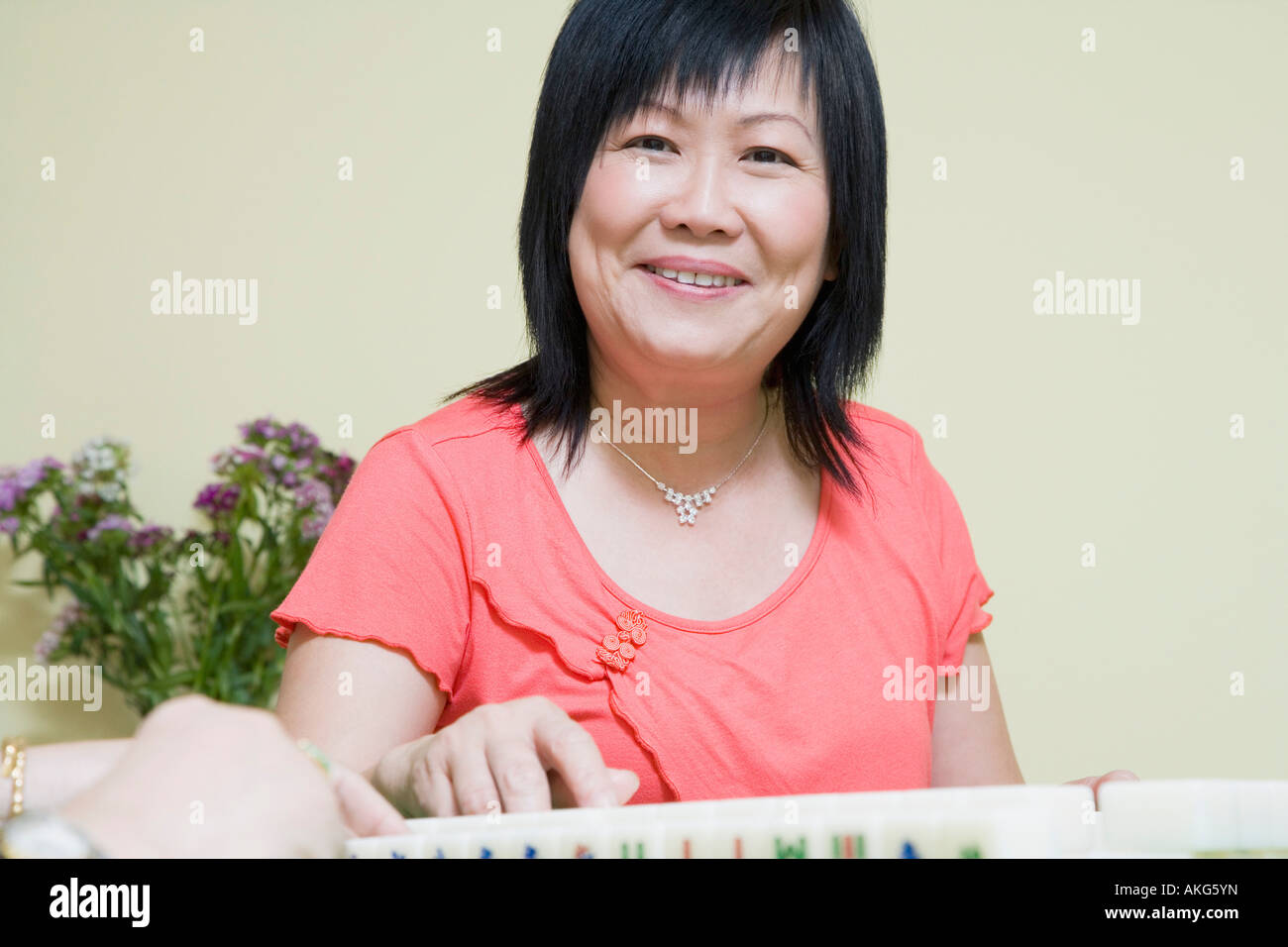 Portrait of a mature woman playing mahjong and smiling Stock Photo - Alamy