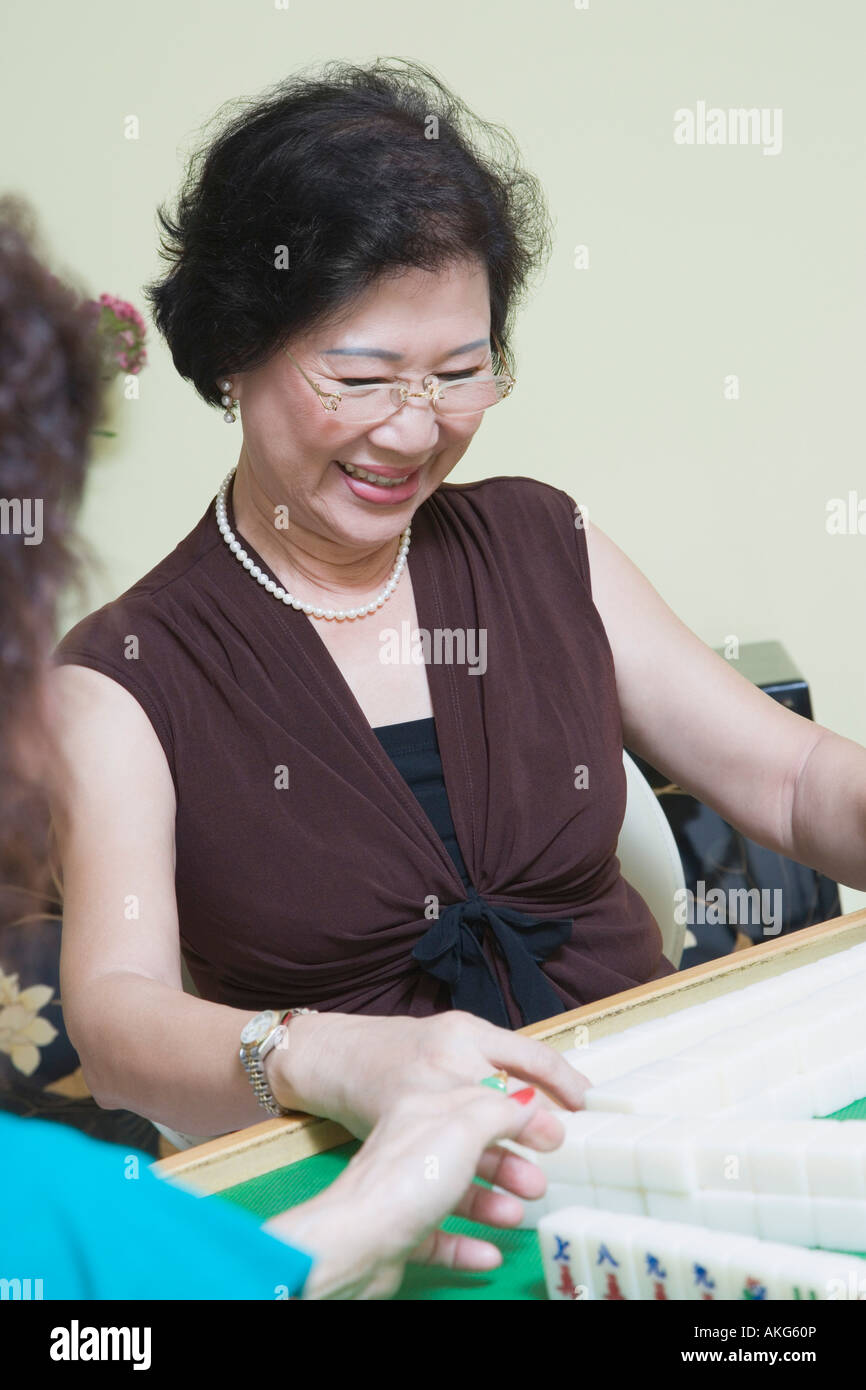 Senior woman playing mahjong and smiling Stock Photo - Alamy