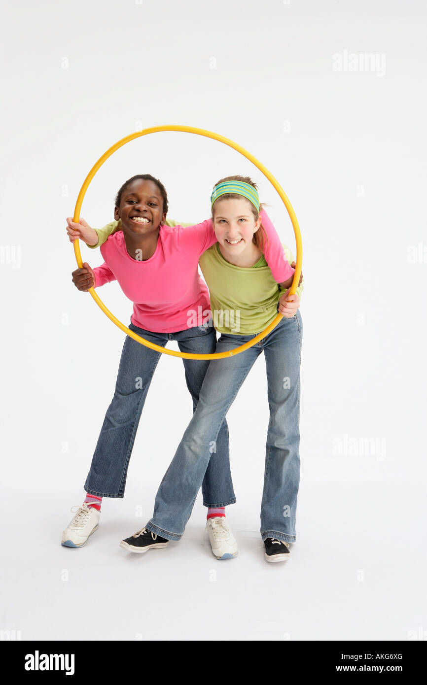 Girls holding yellow hula hoop Stock Photo - Alamy