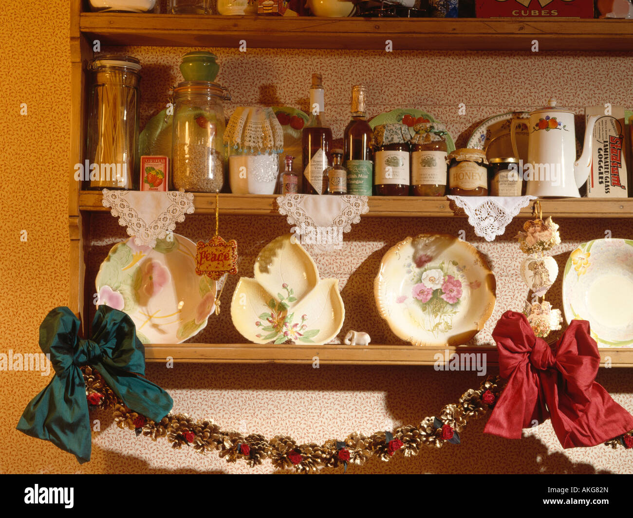 Carltonware and jars of preserves on wooden shelves decorated with ...