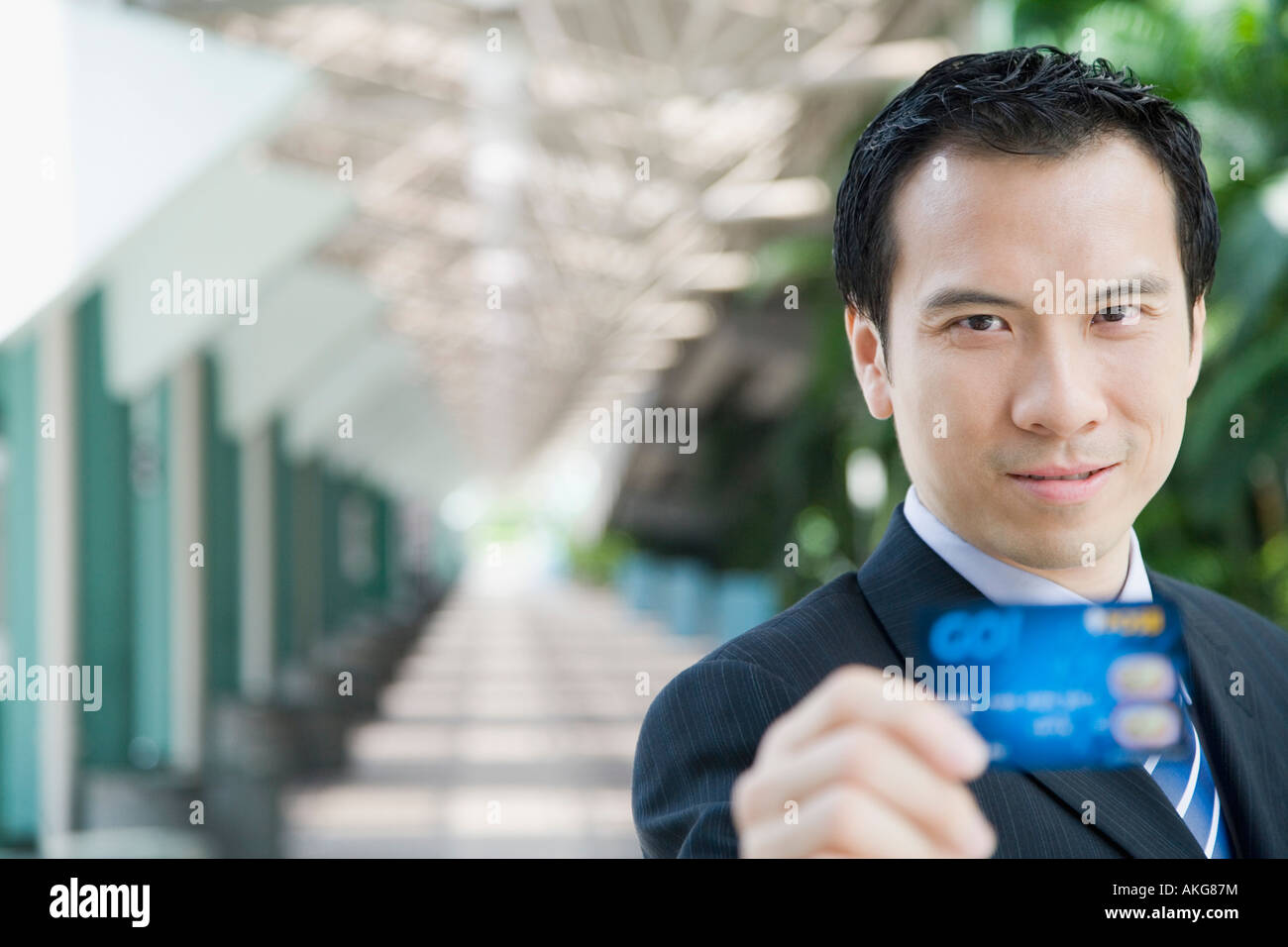 Portrait of a businessman showing a credit card Stock Photo - Alamy