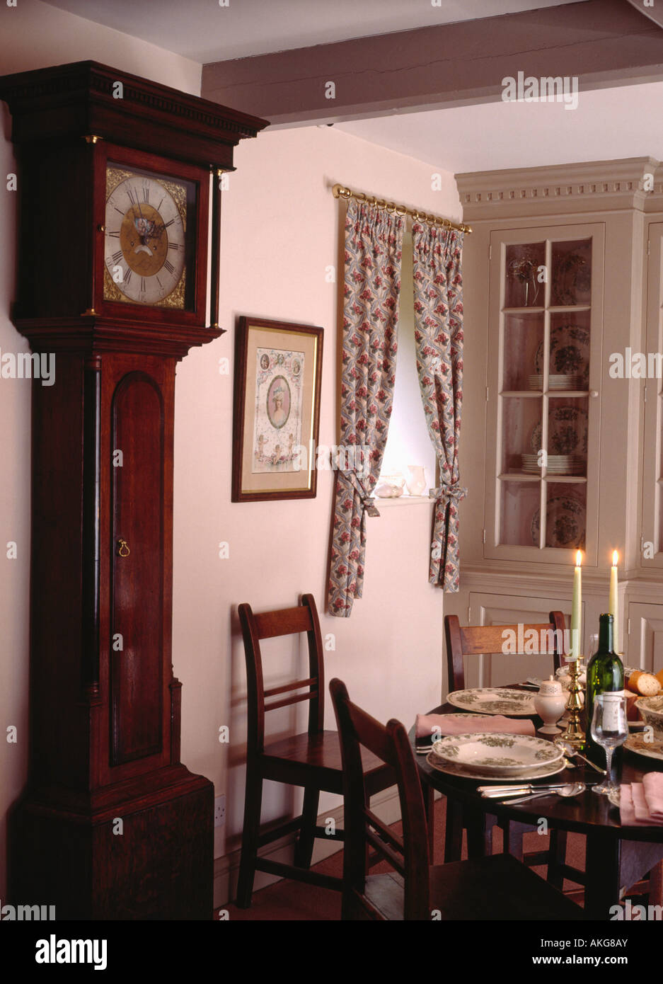 Antique longcase clock in pastel pink cottage diningroom with patterned ...