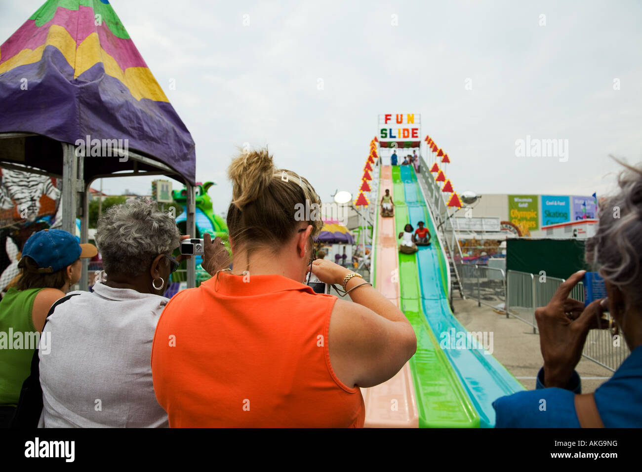 WISCONSIN Milwaukee Several women photograph their children on slide at ...
