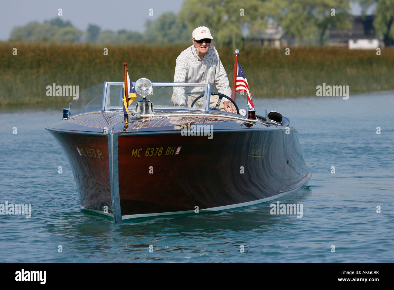 A senior man enjoying his antique wooden boat Stock Photo - Alamy