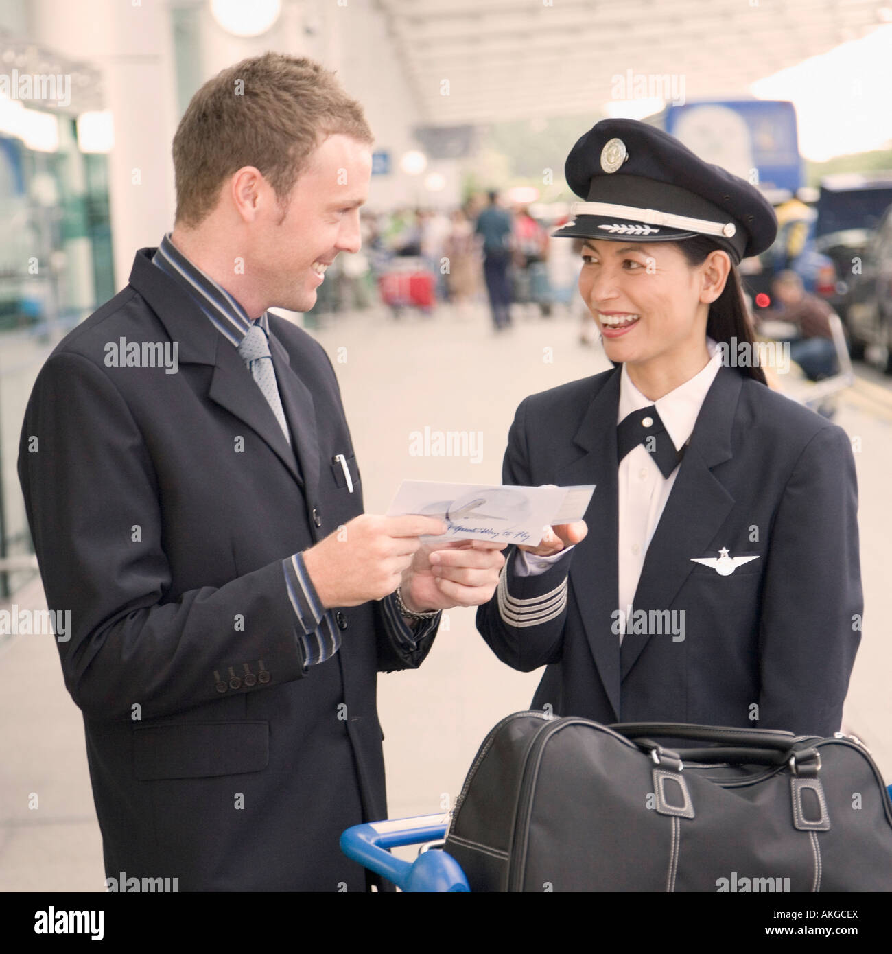 Businessman and a female pilot looking at each other and smiling Stock ...