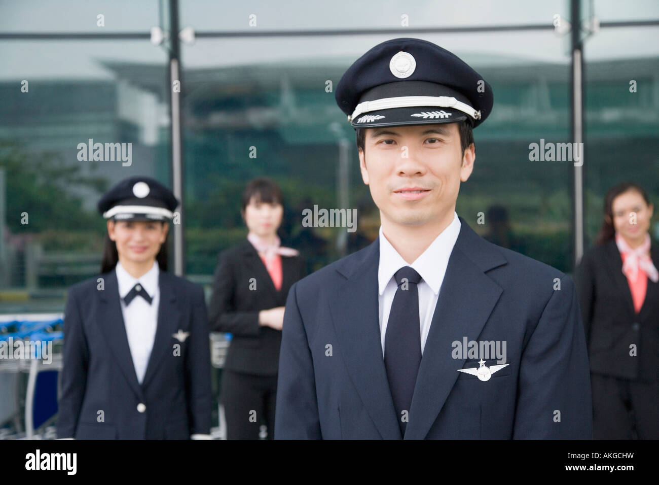 Portrait of a pilot with a female pilot and two cabin crews standing in ...