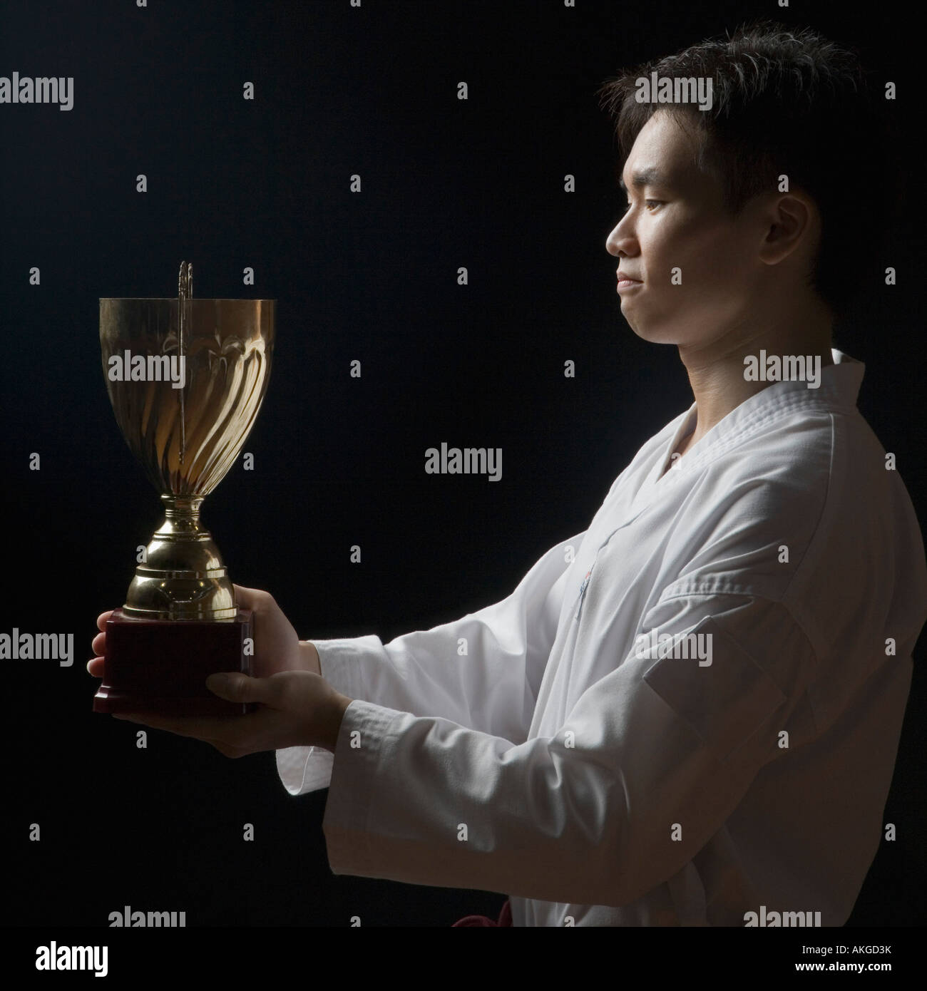 Side profile of a young man holding a trophy Stock Photo - Alamy