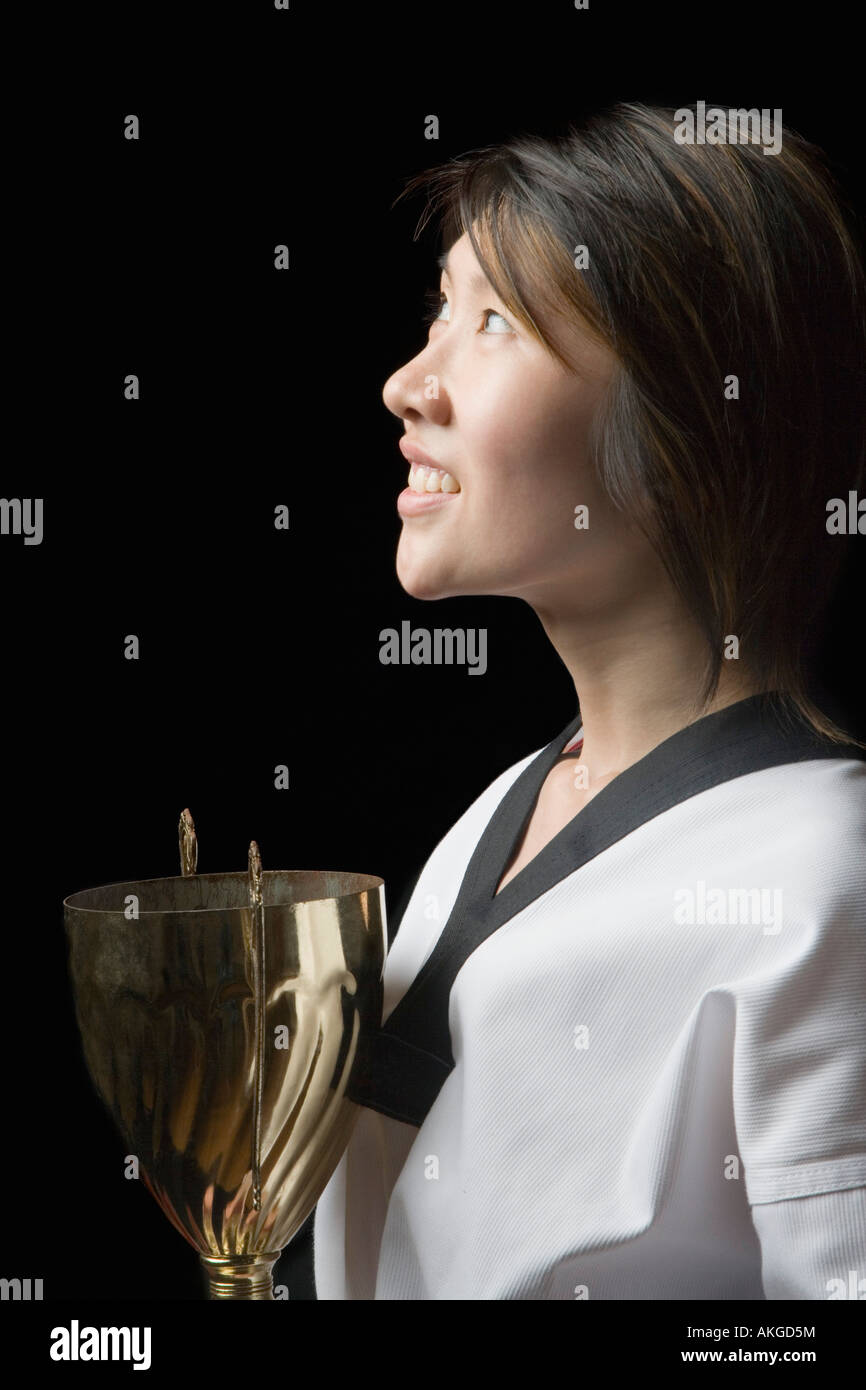 Side profile of a young woman holding a trophy Stock Photo - Alamy