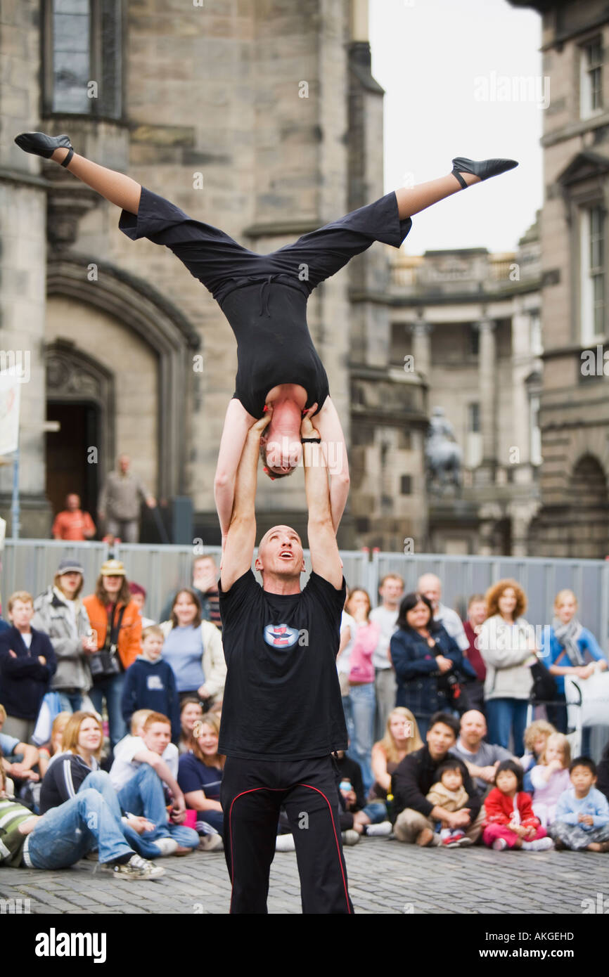 Female acrobat balancing upside down on shoulders of partner at ...