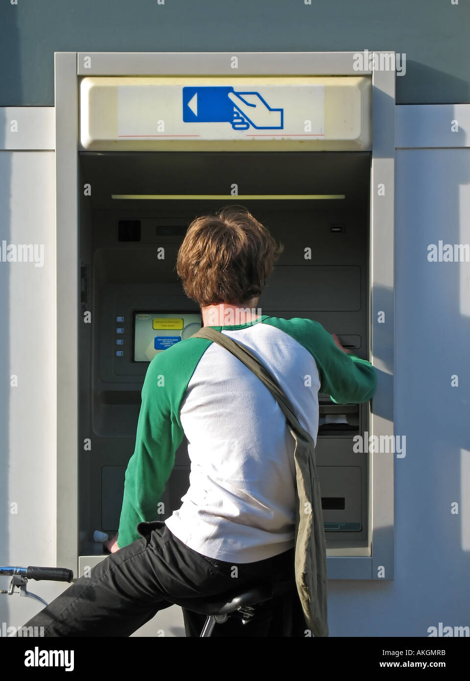 Rear view of a young man withdrawing cash at bank's ATM, Colmar, Alsace ...