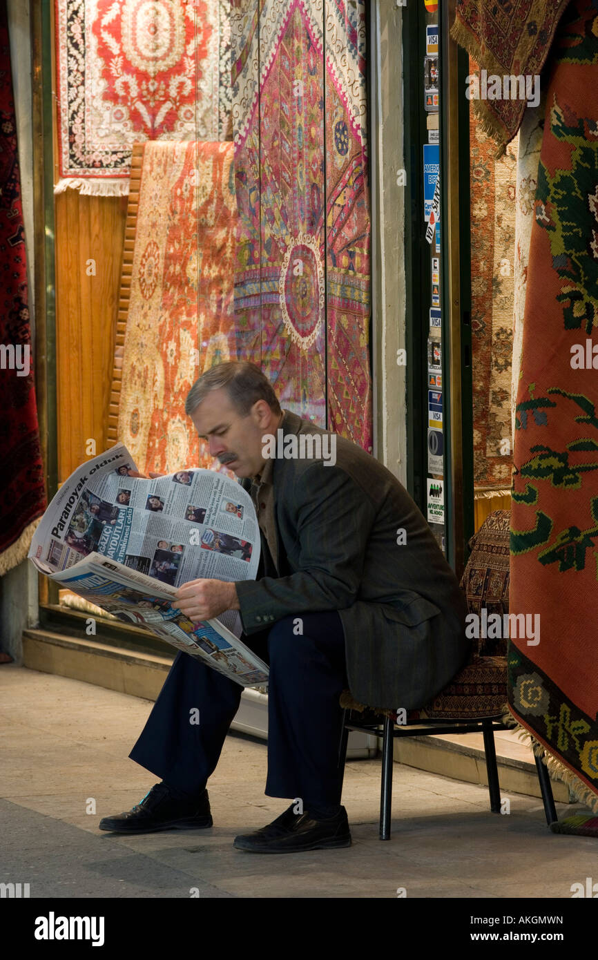 Turkey, Istanbul, Grand Bazaar, carpet dealer reading newspaper Stock ...