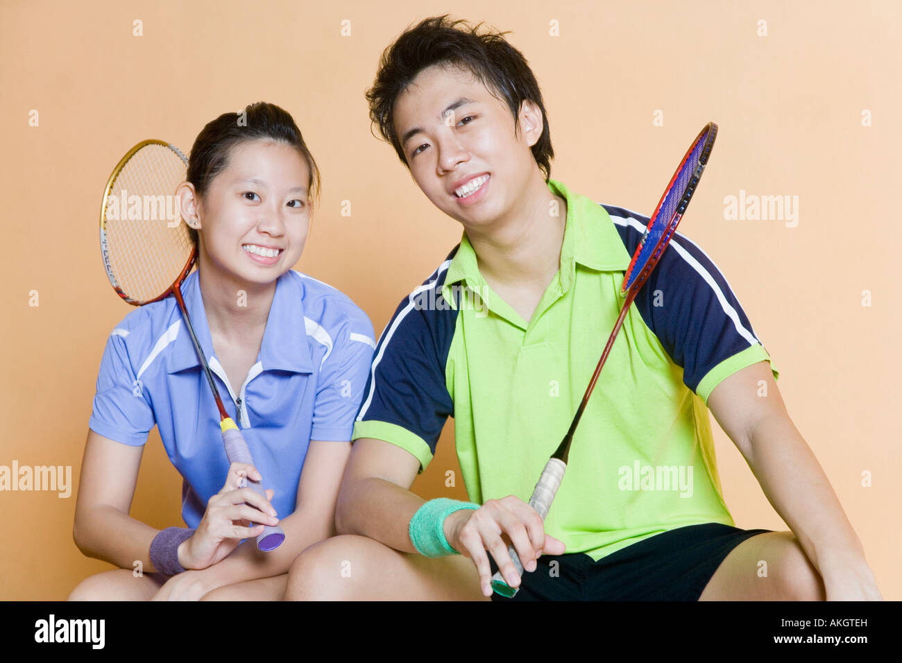 Portrait of a young couple holding badminton rackets and smiling Stock ...