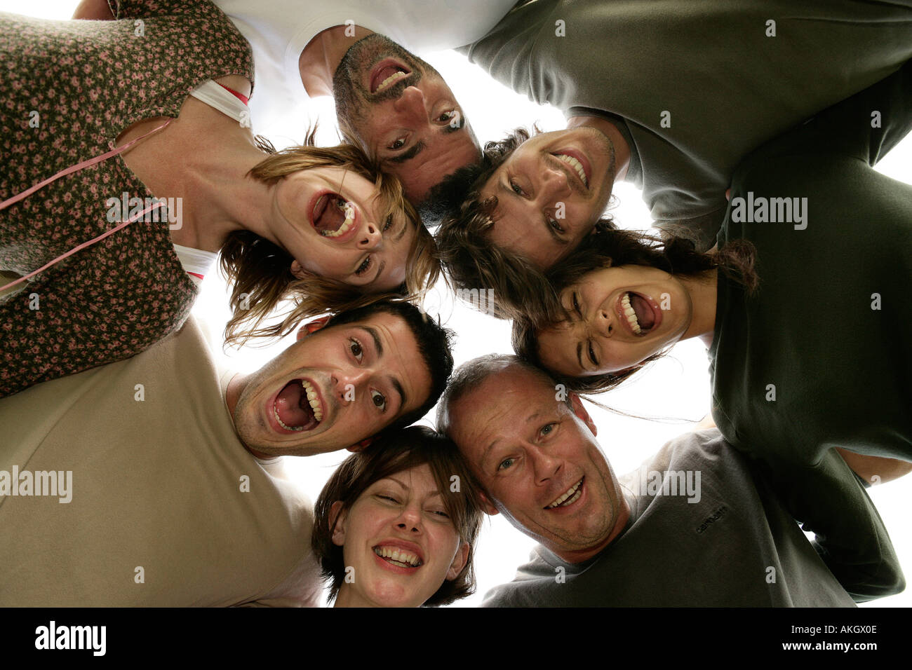 Six heads together looking down laughing Stock Photo - Alamy