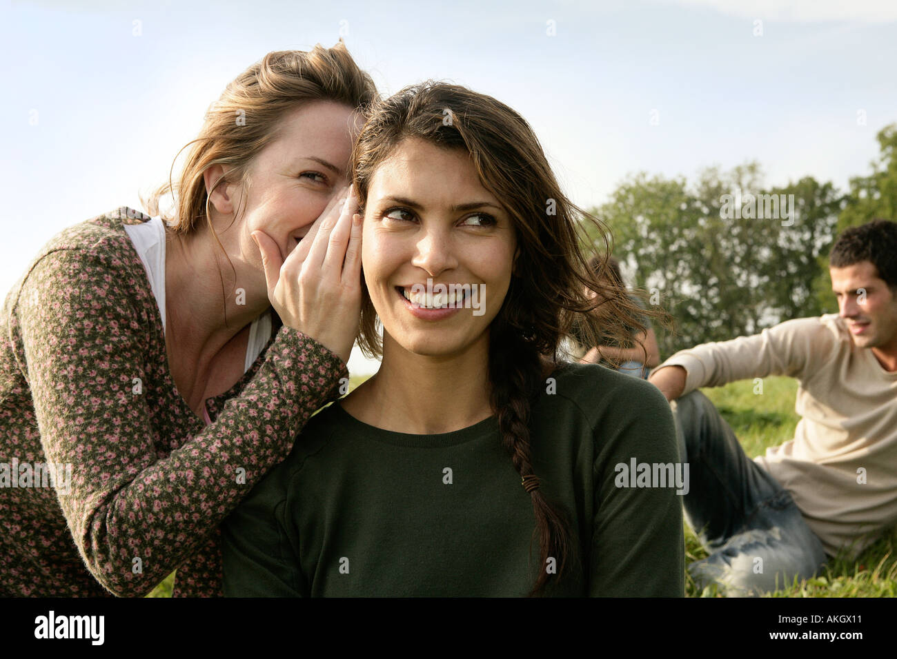 Woman telling her friend a secret Stock Photo - Alamy