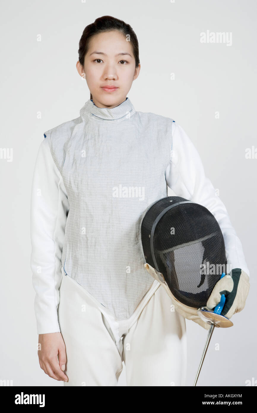 Portrait of a female fencer holding a fencing foil and a fencing mask ...