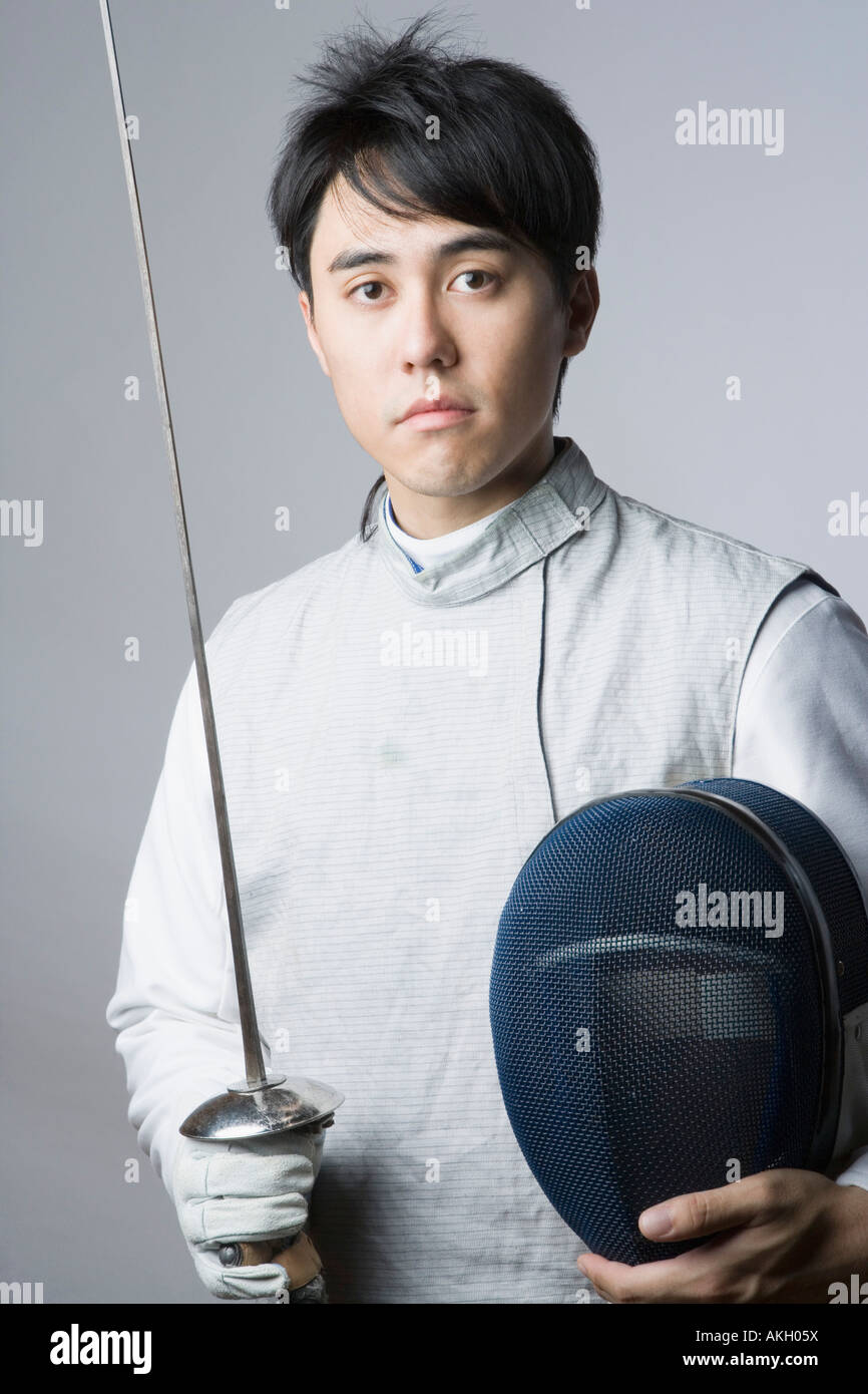 Portrait of a male fencer holding a sword and a fencing mask Stock ...