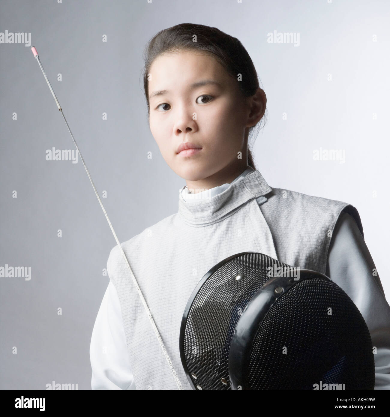 Portrait of a female fencer holding a sword and a fencing mask Stock Photo - Alamy