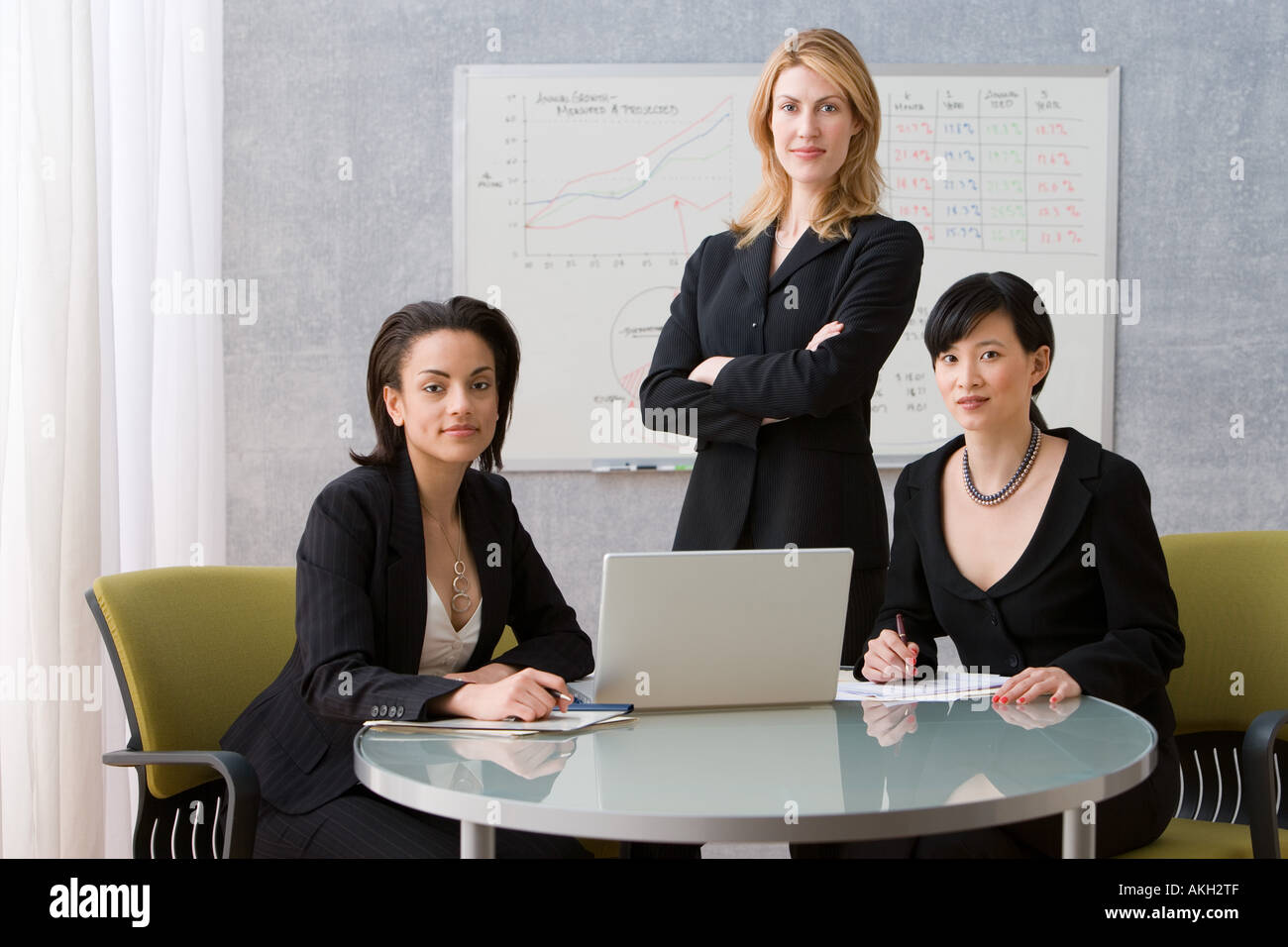 Three young women conference room Stock Photo - Alamy