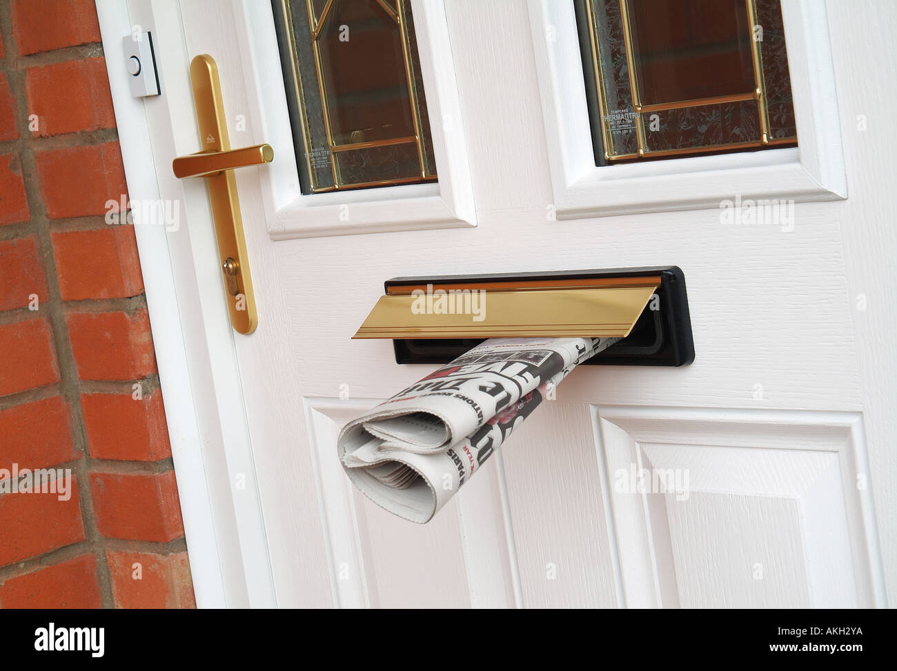 newspaper in letterbox on white door Stock Photo - Alamy
