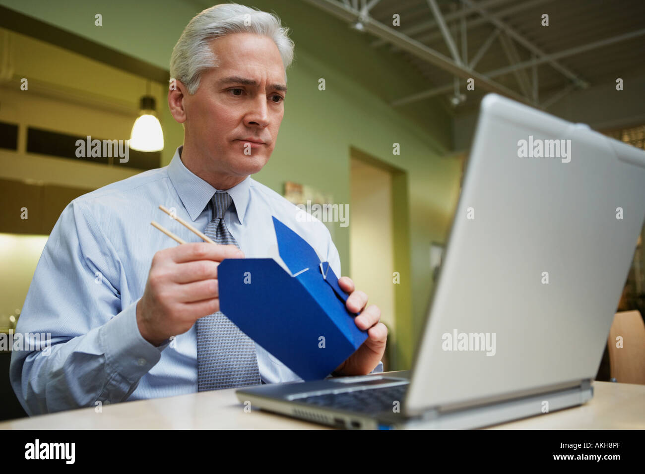 Man eating chinese food at desk Stock Photo - Alamy
